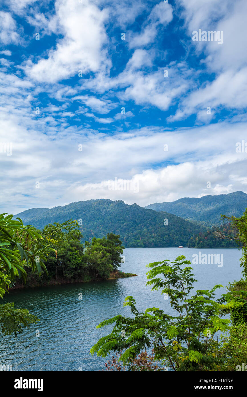 Tropical lake, forest and islands in cloudy blue sky. Belum resort ...