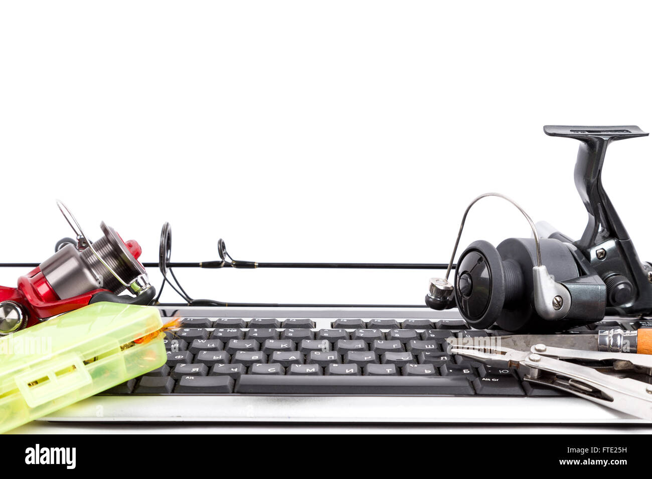 different fishing tackles on computer keyboard with white background ...