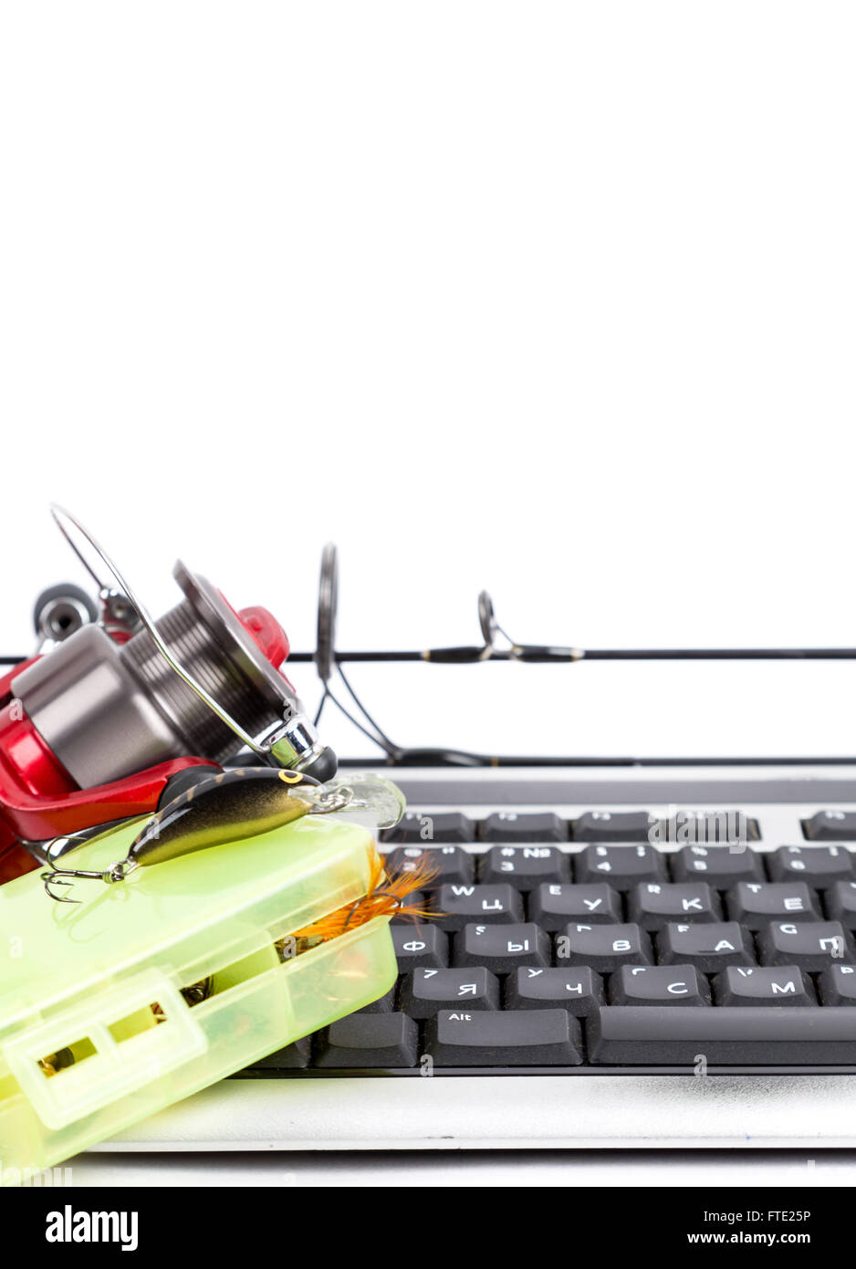different fishing tackles on computer keyboard with white background ...