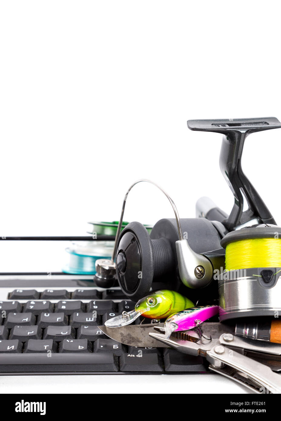 different fishing tackles on computer keyboard with white background ...
