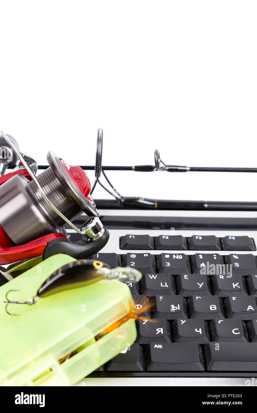 different fishing tackles on computer keyboard with white background ...