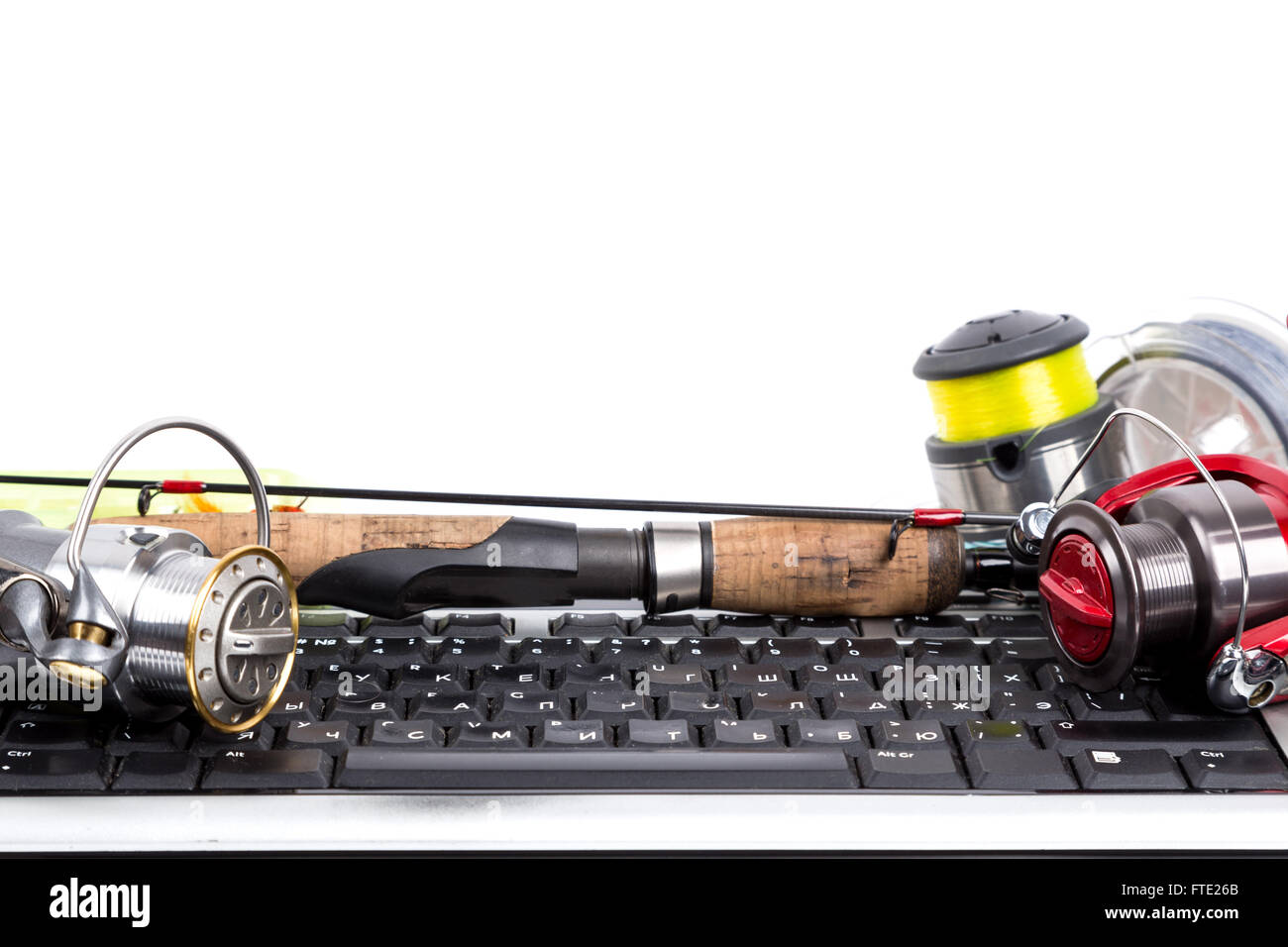 different fishing tackles on computer keyboard with white background ...