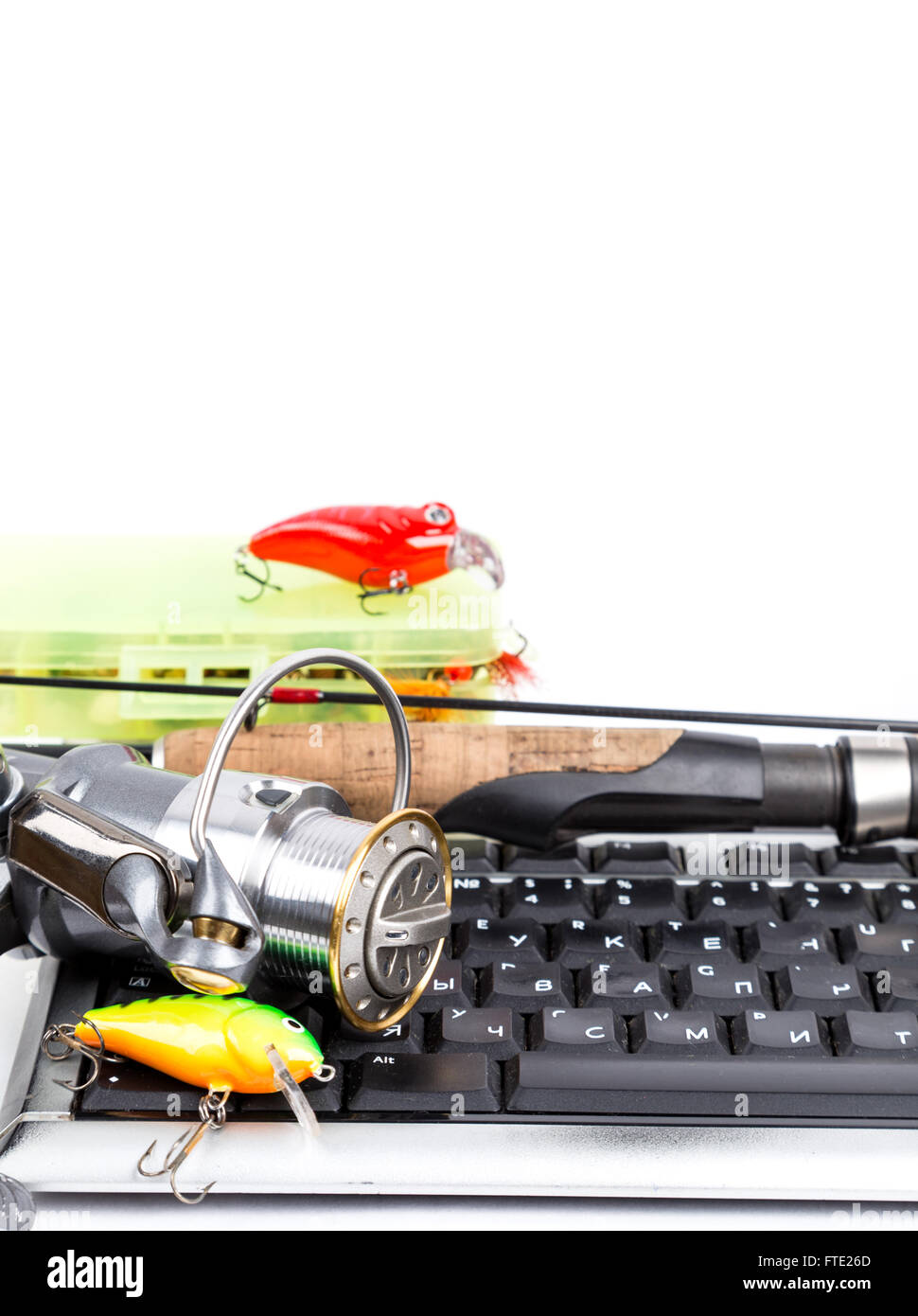 different fishing tackles on computer keyboard with white background ...