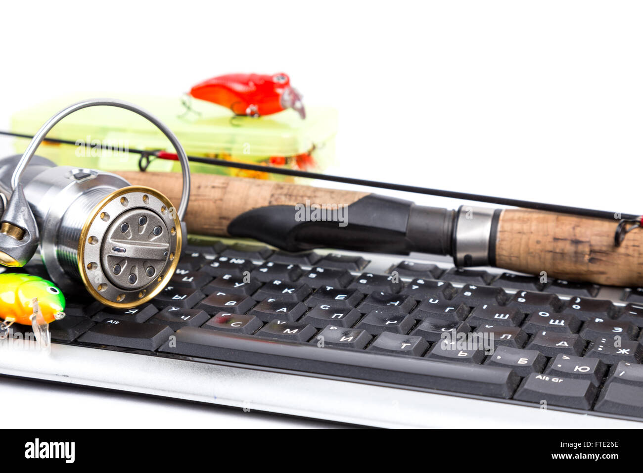 different fishing tackles on computer keyboard with white background ...