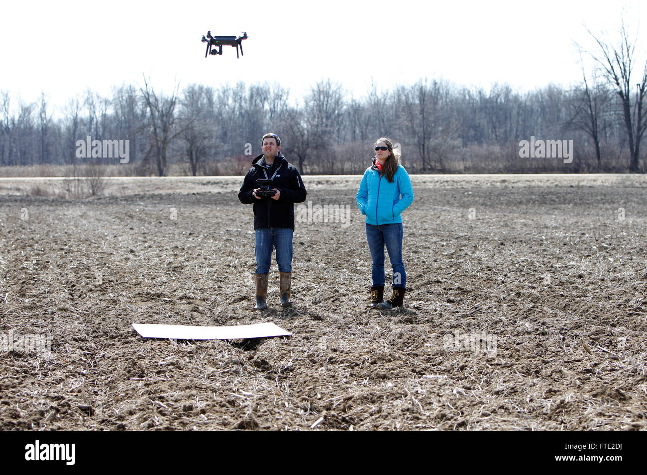 A young couple flying a drone over a field Stock Photo - Alamy