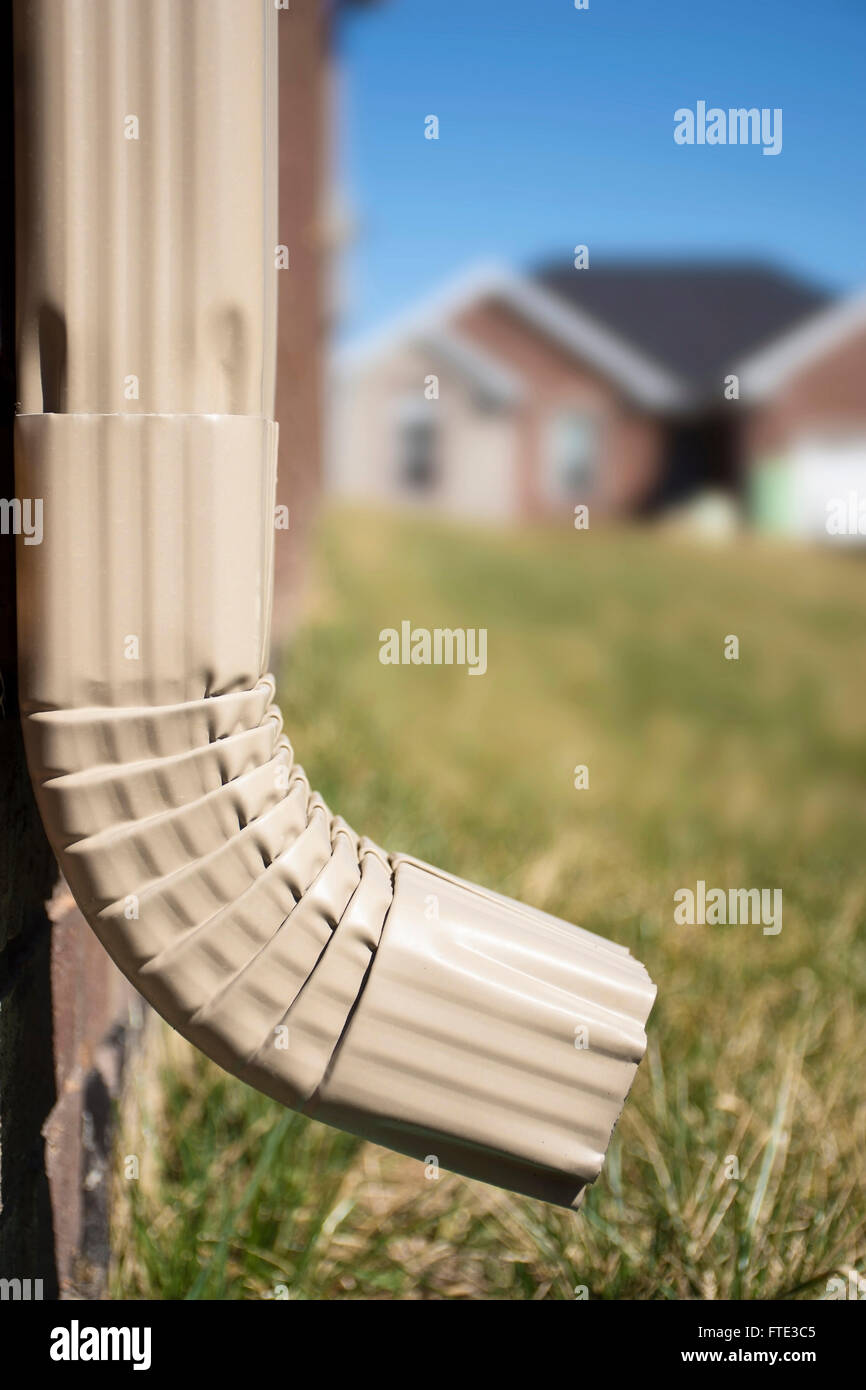 Downspout of a gutter showing a house in the background Stock Photo - Alamy