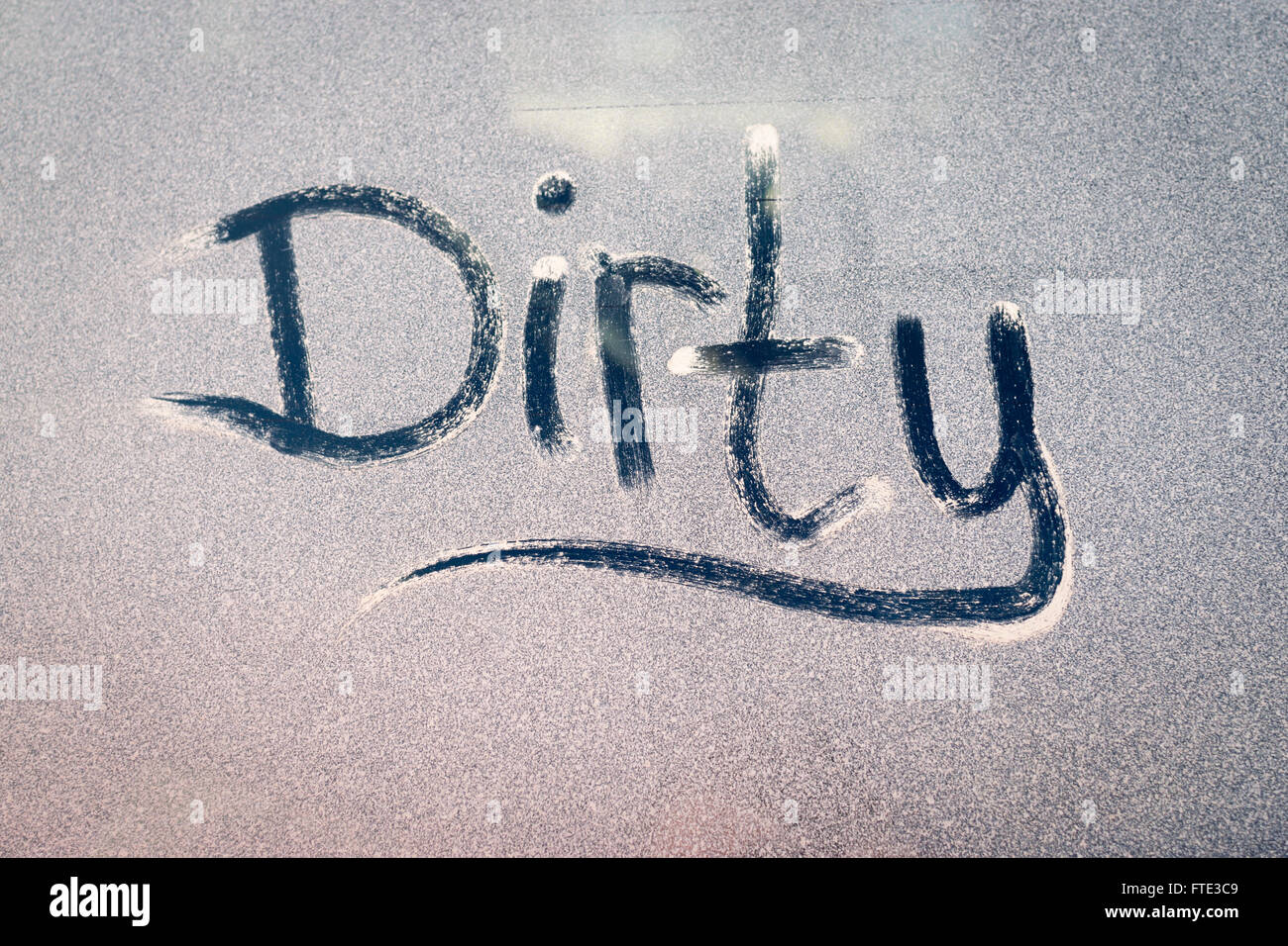 The word Dirty text etched into the dirty grubby window of a window ...