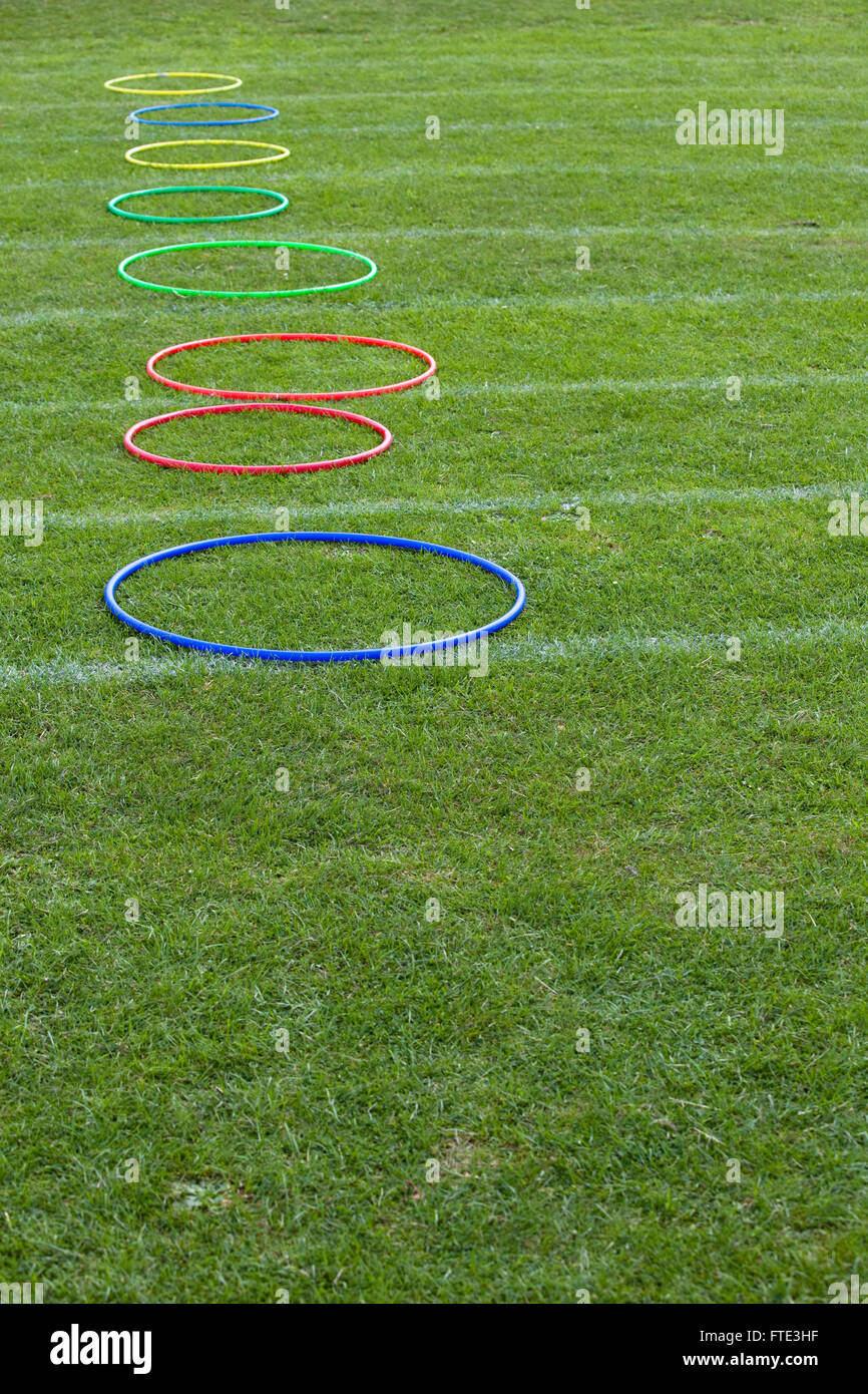 Coloured hoope lined up on a school field ready for the sports day ...