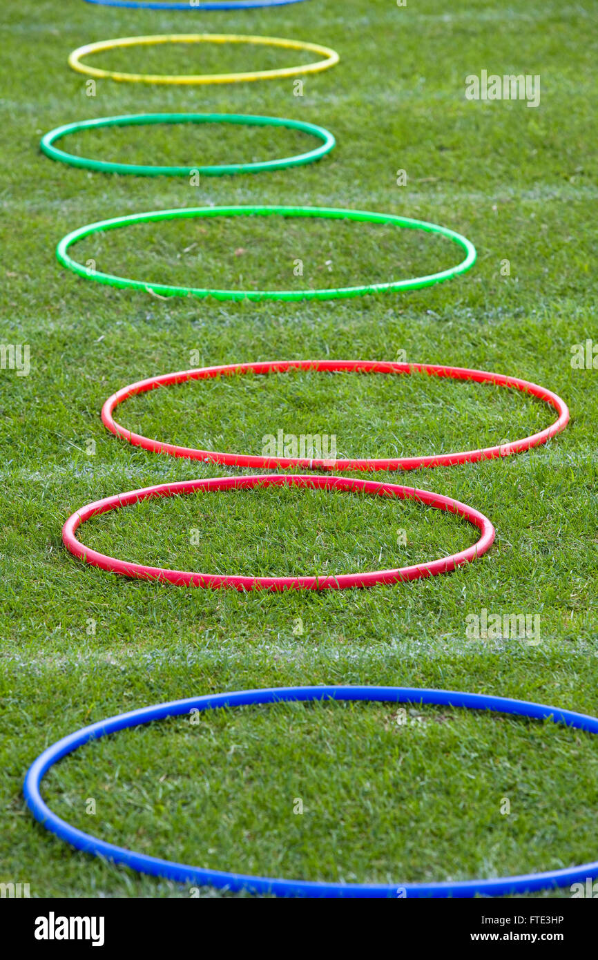 Coloured hoope lined up on a school field ready for the sports day ...