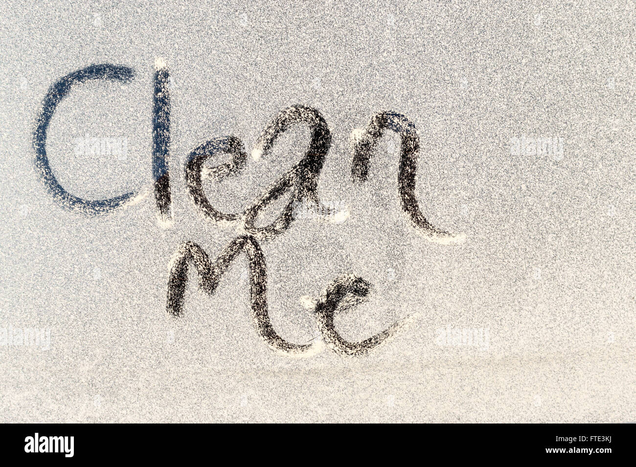Clean Me text etched into the dirty grubby window of a window Stock ...
