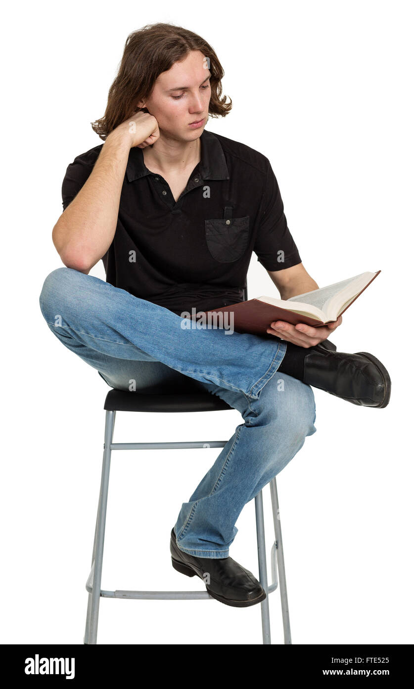 Young man sits on a chair and reading a book Stock Photo - Alamy
