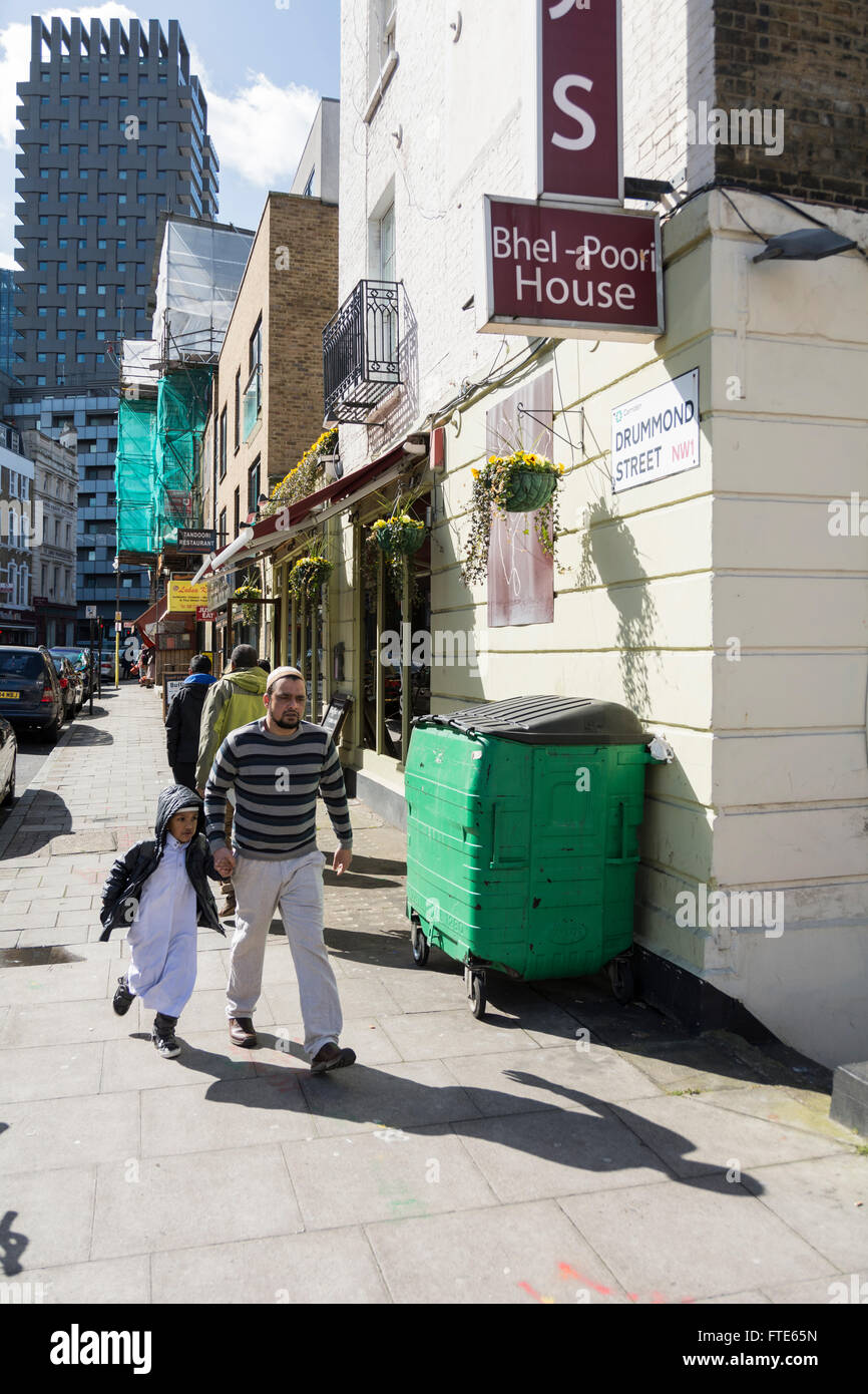 Father and son walk, hand-in-hand, past Bhel-Poori houses in London's ...