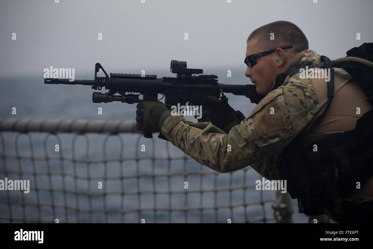 Fire Controlman 2nd Class Duke Batteate is seen shooting an M4 rifle ...