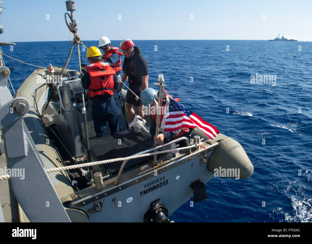 In this image, Engineman 2nd Class Cherrilyn Alonzo raises the ensign ...