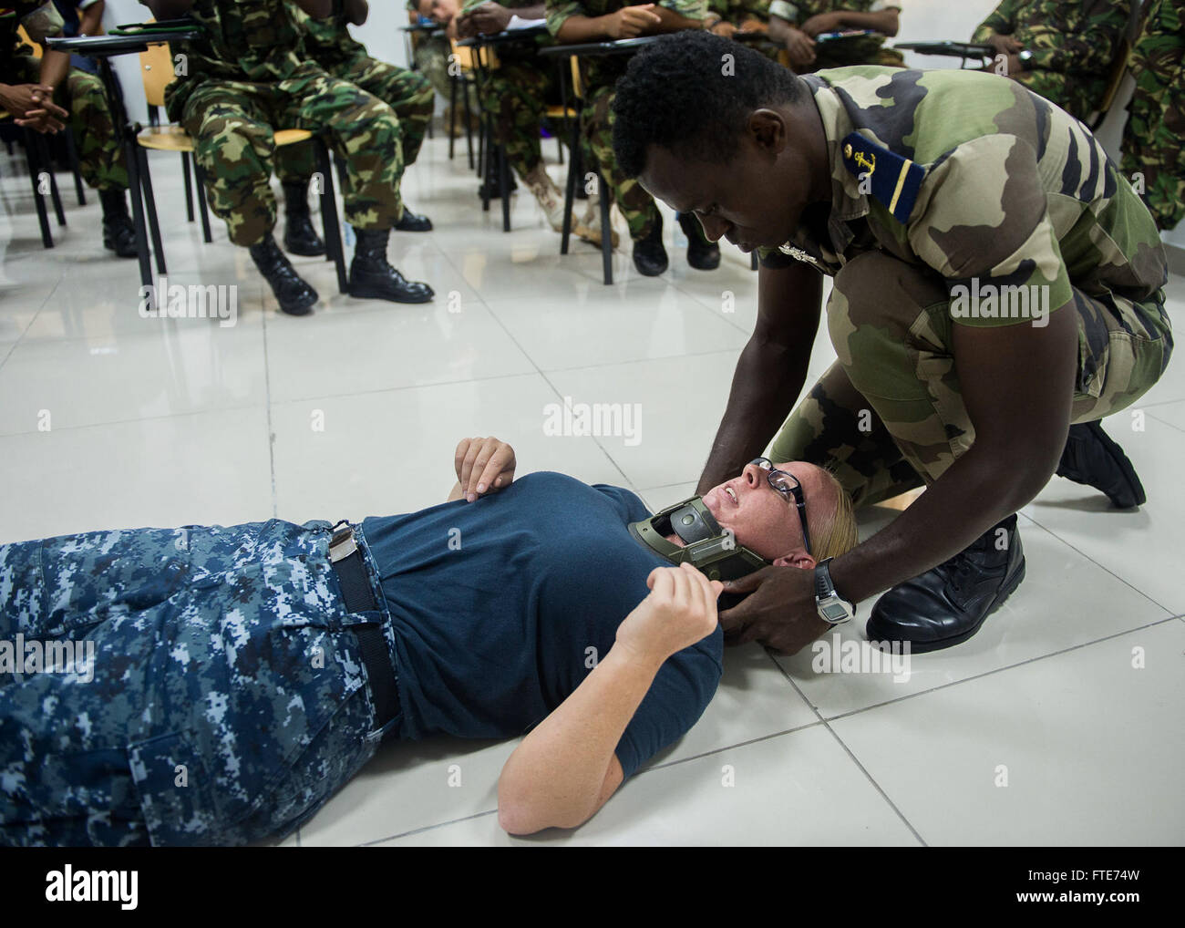 The image shows a medical team member applying a neck brace to a ...