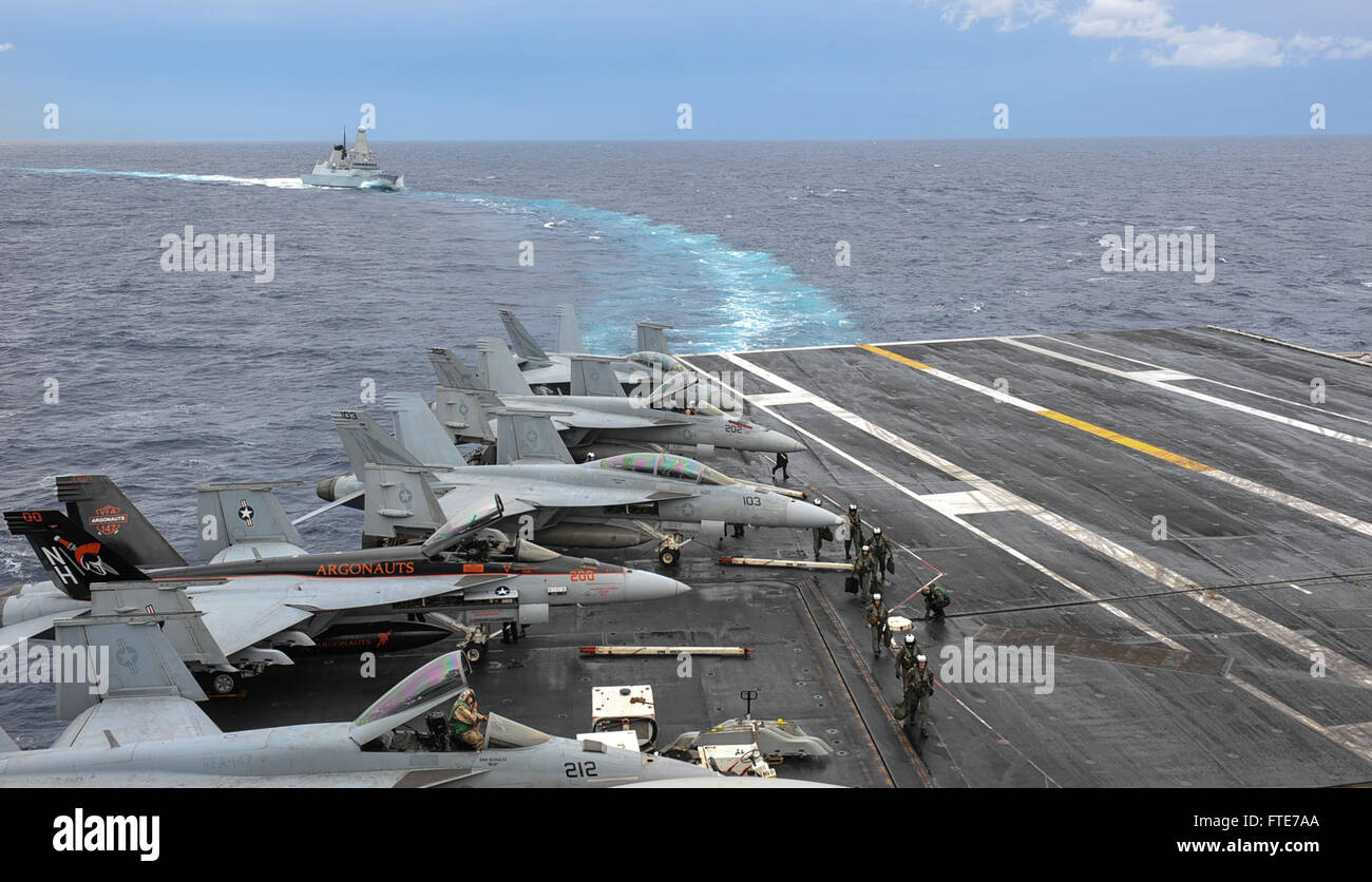 The photograph shows U.S. Navy sailors on the flight deck of the USS ...