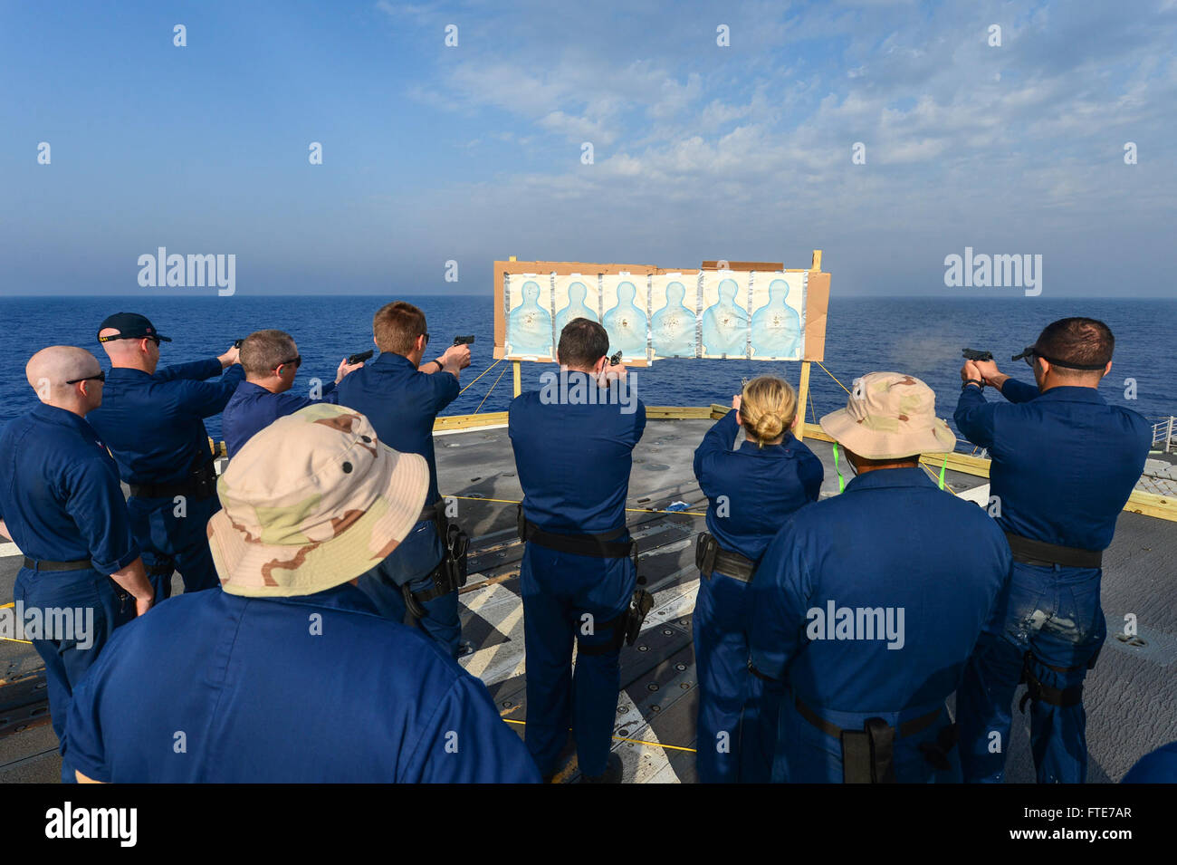 This image captures sailors aboard the USS Monterey (CG 61) firing 9mm ...