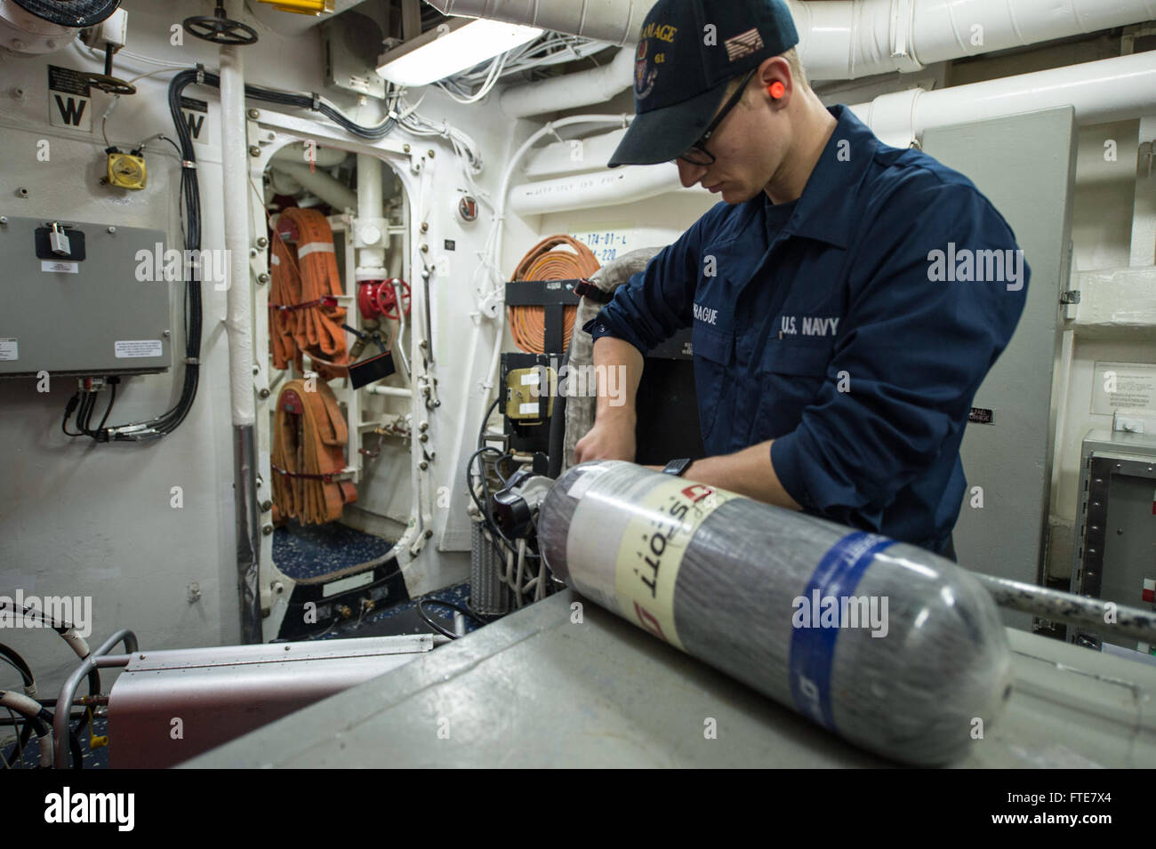 The image shows Damage Controlman Fireman Hunter Sprague refilling Self ...