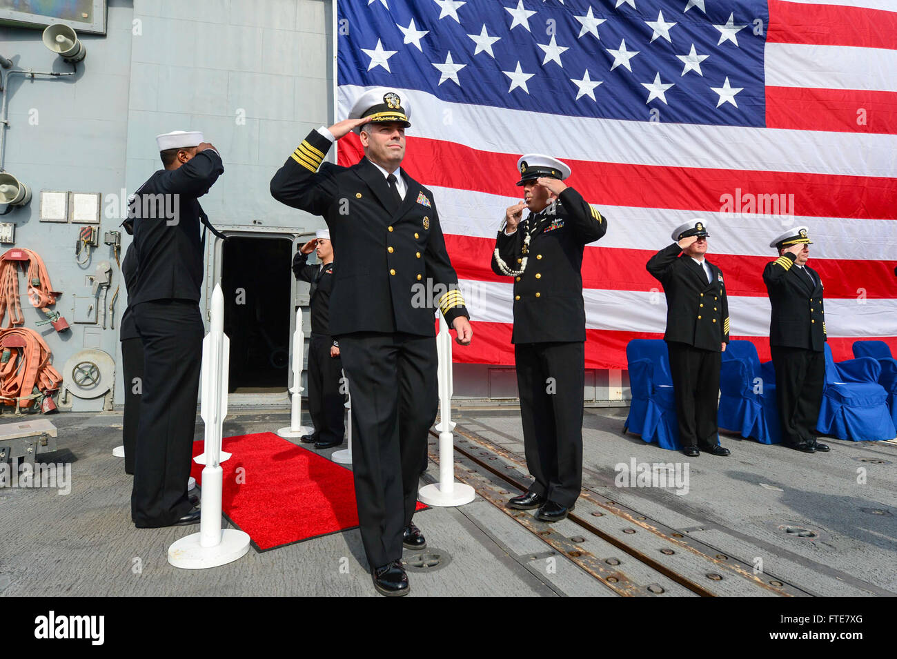 The photograph captures a change of command ceremony aboard the USS ...