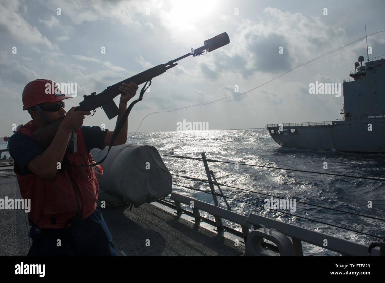 This image shows Gunner's Mate 2nd Class Gregory Spaulding firing a ...