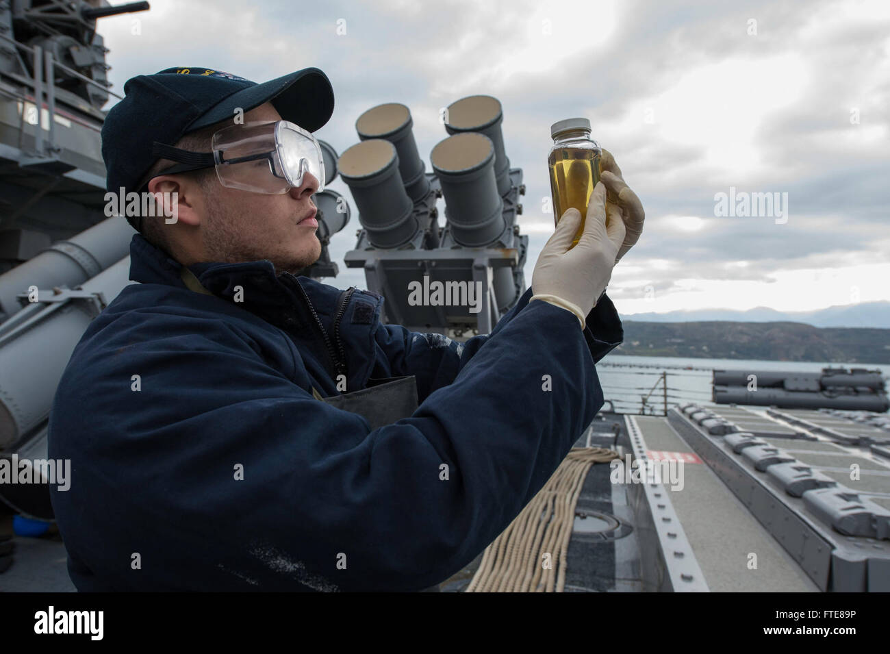 Electrician's Mate 3rd Class Ariel Vasquez examines a fuel sample while ...