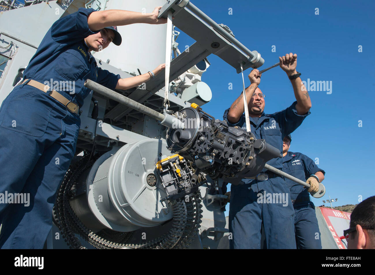 Fire Controlman 1st Class Robert Miller installs a 20mm cannon on the ...