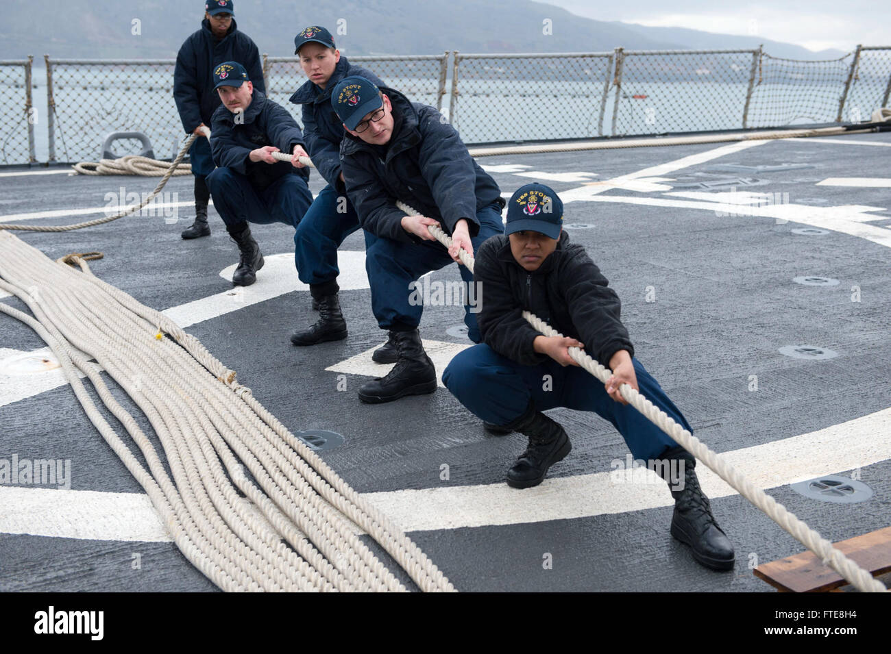 Sailors aboard the USS Stout (DDG 55) handle mooring lines while ...