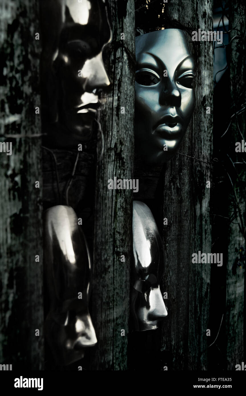Trapped - Masks behind Weathered Fence Stock Photo - Alamy