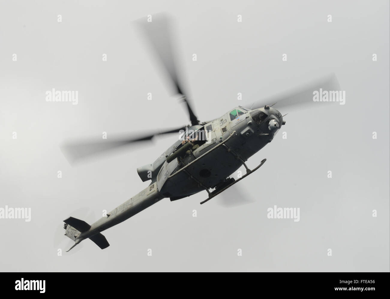 A UH-1 Huey helicopter is seen preparing to land on the USS Bataan (LHD ...