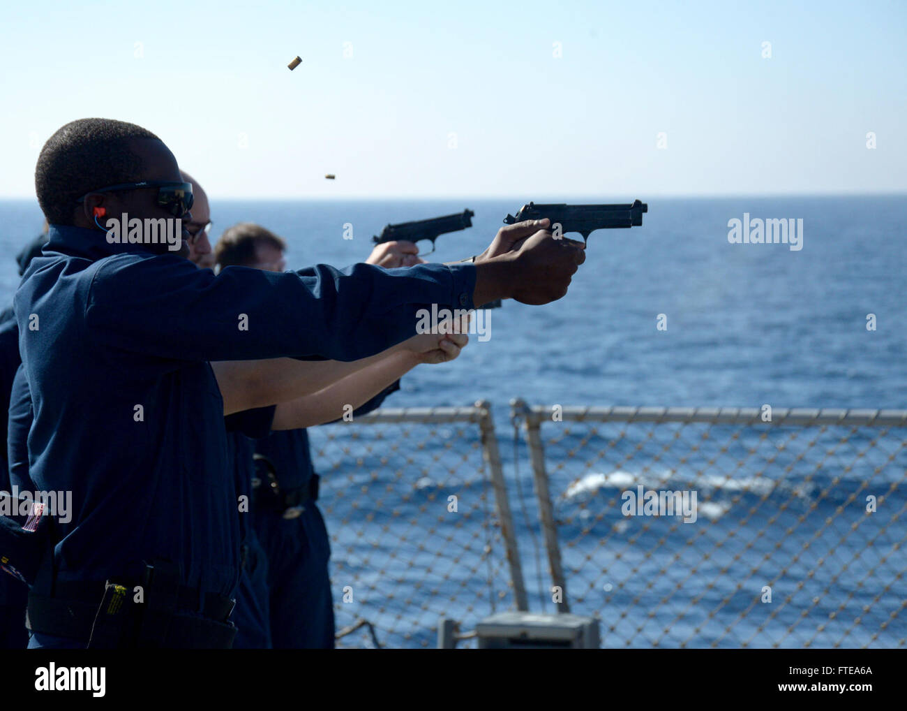 Fire Controlman 1st Class Christopher Green fires a 9mm pistol during ...