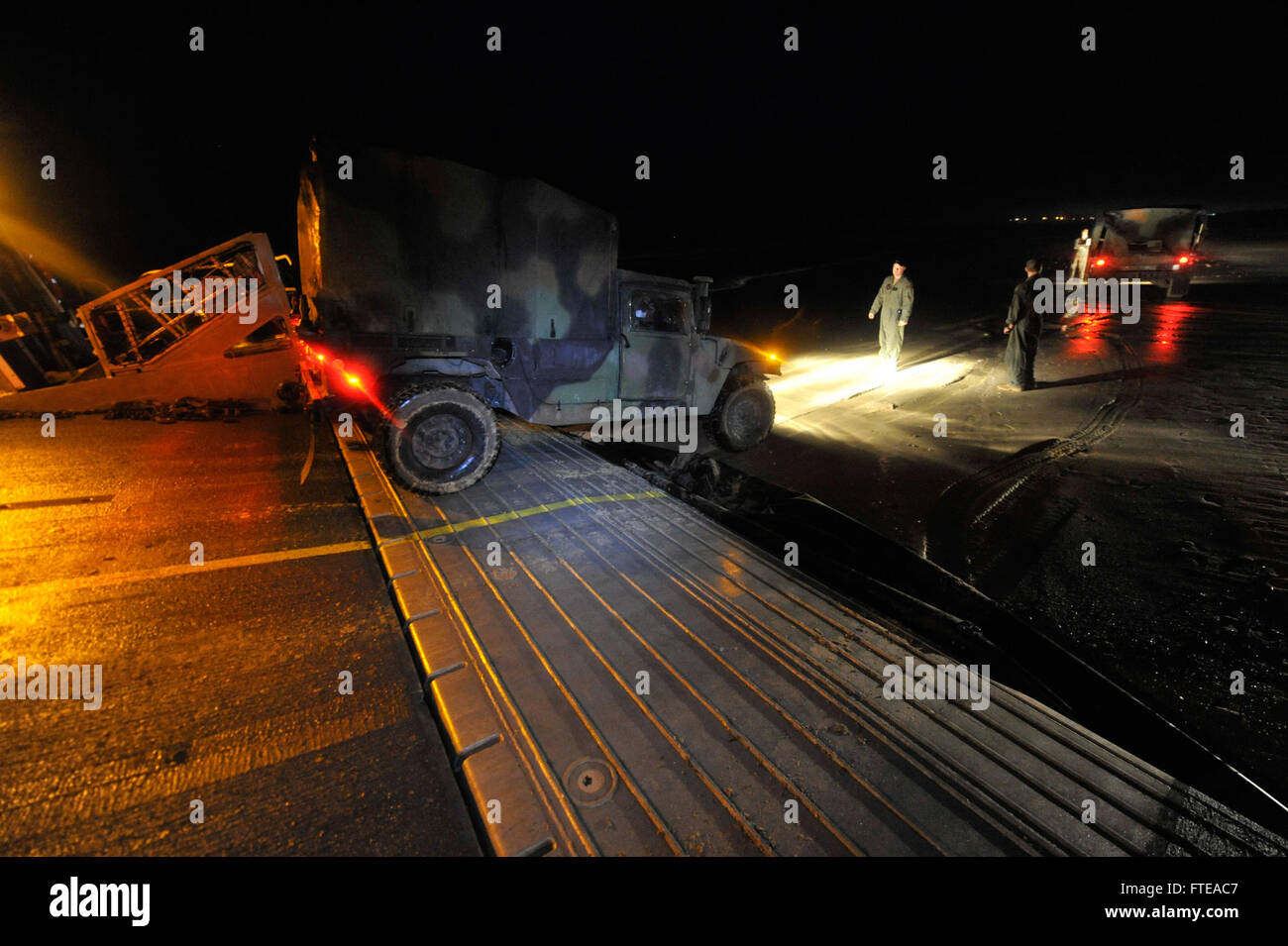 A photograph of sailors and Marines loading vehicles onto a Landing ...