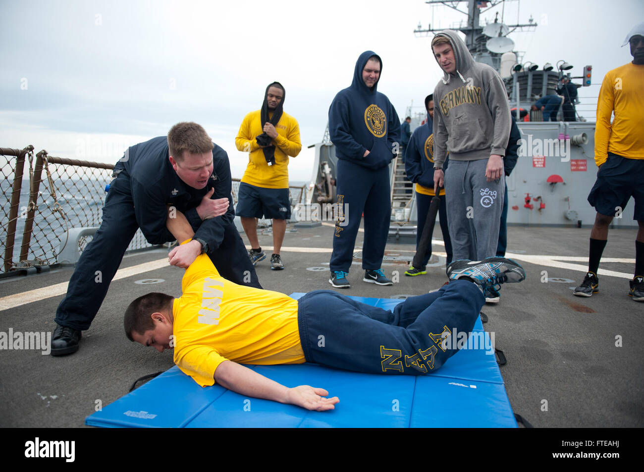 A U.S. Navy sailor demonstrates a self-defense maneuver aboard the USS ...