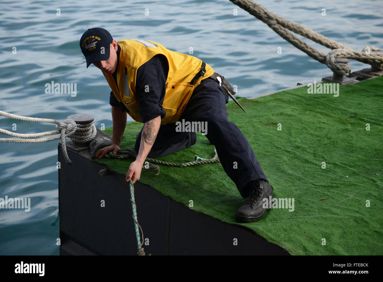 Boatswain's Mate 3rd Class Brendon Drew secures a mooring line to the ...