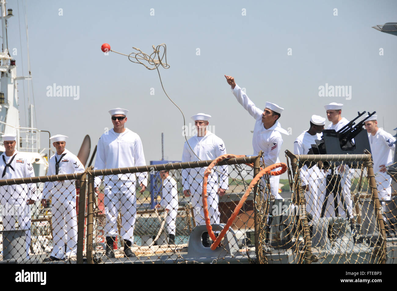 A sailor aboard the USS Donald Cook (DDG 75) tosses a line as the ship ...