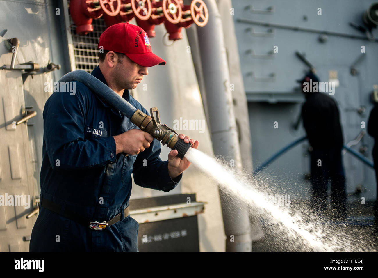 Damage Controlman 2nd Class Abdullah Dadali aboard USS Donald Cook (DDG 75) performs a ...
