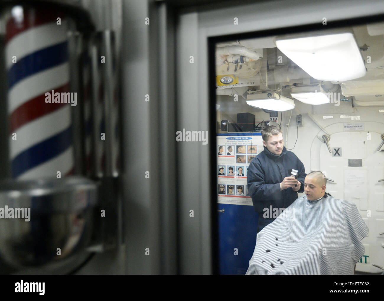 A photo taken aboard the USS Ramage shows Seaman Michael Manos giving ...