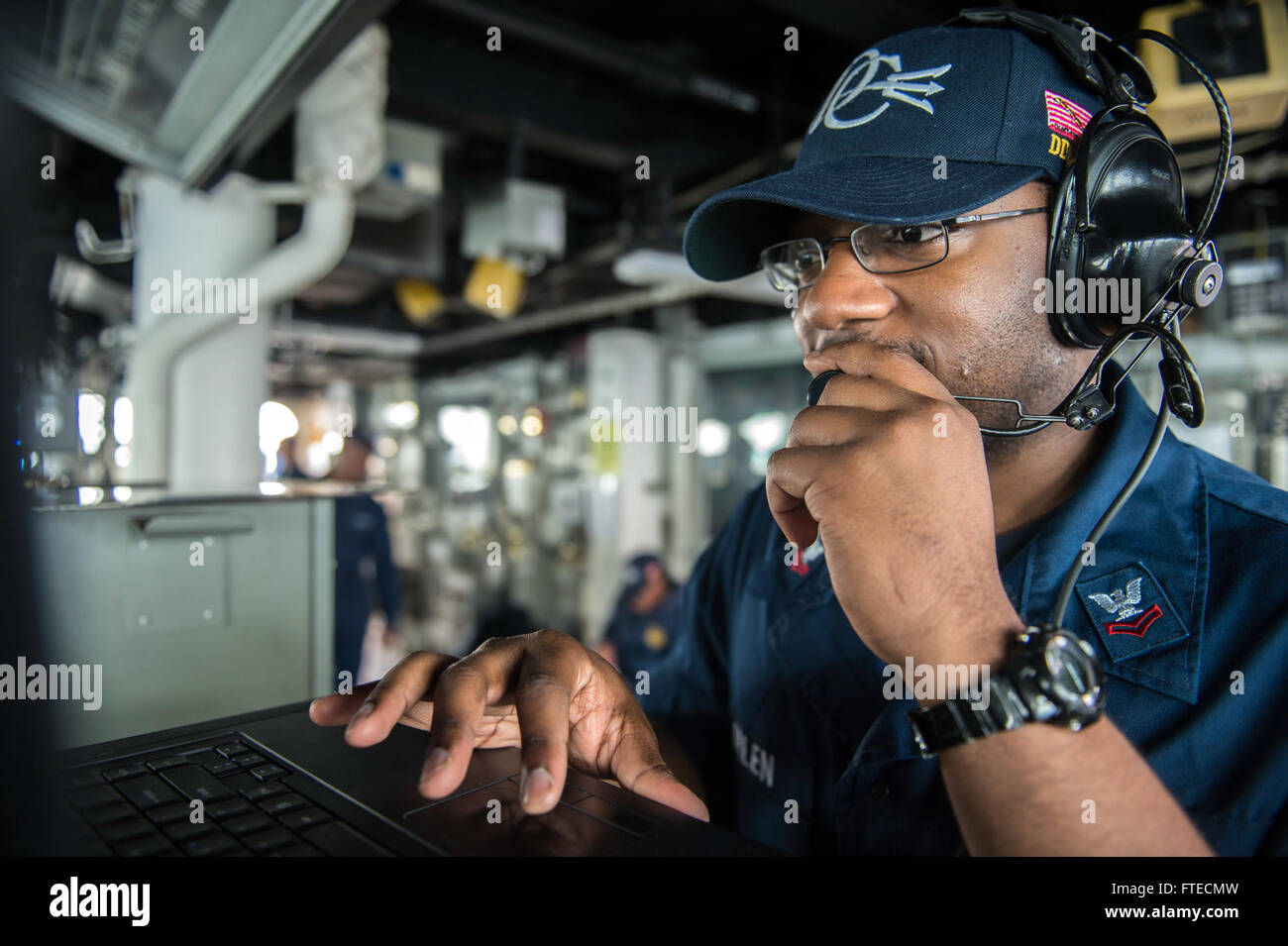 A U.S. Navy Operations Specialist monitors an automated information ...