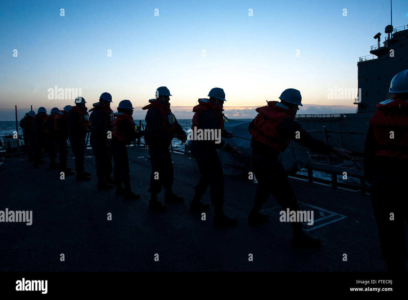 Sailors aboard the USS Ross (DDG 71) conduct an underway replenishment ...