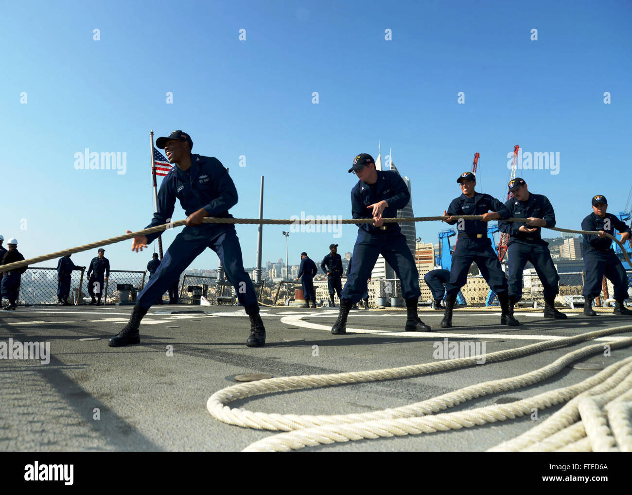 This photograph shows sailors aboard the USS Ramage (DDG 61) heaving a ...