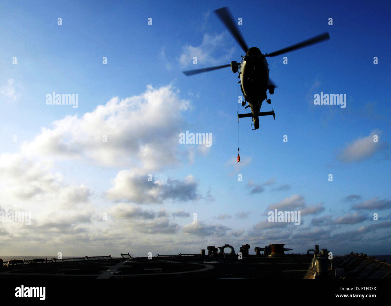 An AS565 Panther helicopter conducts a vertical replenishment with the ...