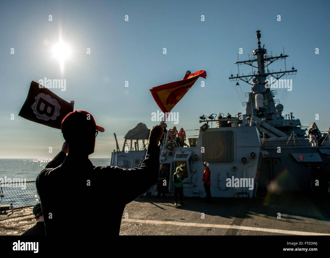 This image features Chief Hull Technician Jonathan Fitzgerald signaling ...