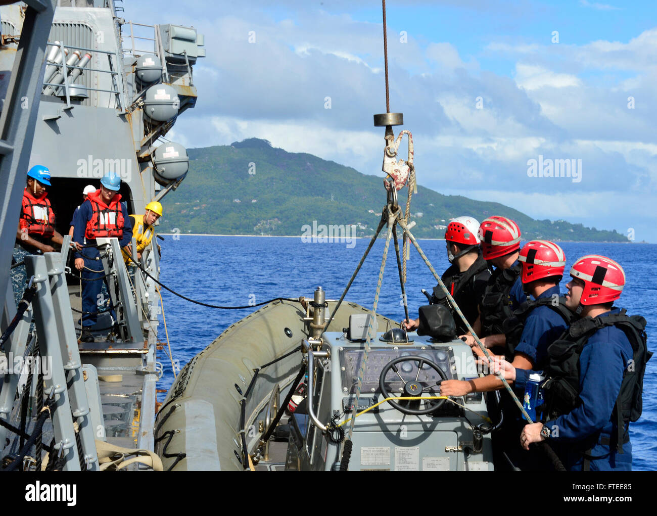 Sailors aboard the USS Nitze (DDG 94) raise a rigid-hull inflatable ...