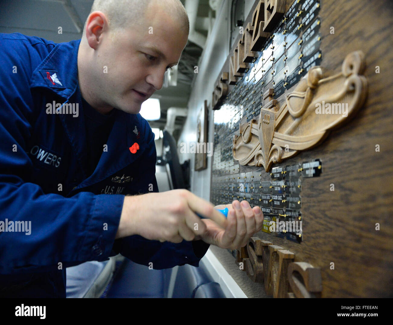 Fire Controlman 2nd Class Mathew Flowers attaches his enlisted warfare ...