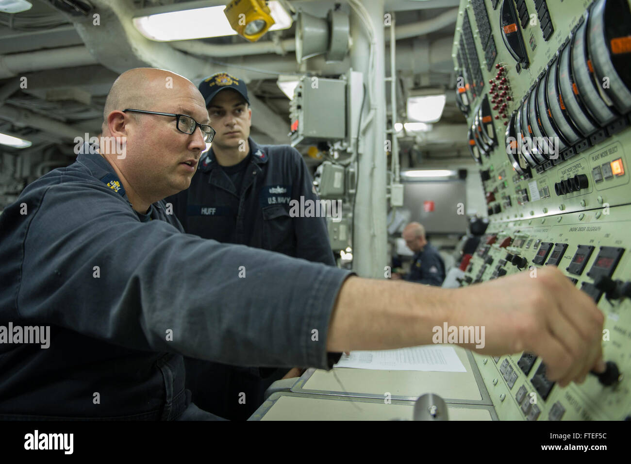 Crew members of the USS Vella Gulf (CG 72) monitor equipment during ...