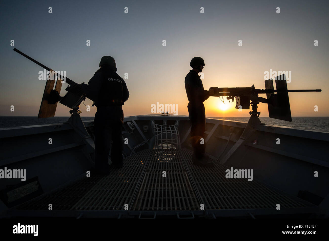 Sailors aboard the USS *Vella Gulf* (CG 72) man .50 caliber machine ...