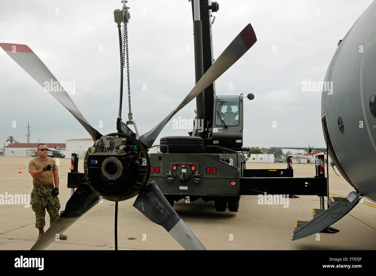 A C-130 aircraft propeller sits on the ground after being lifted by a ...