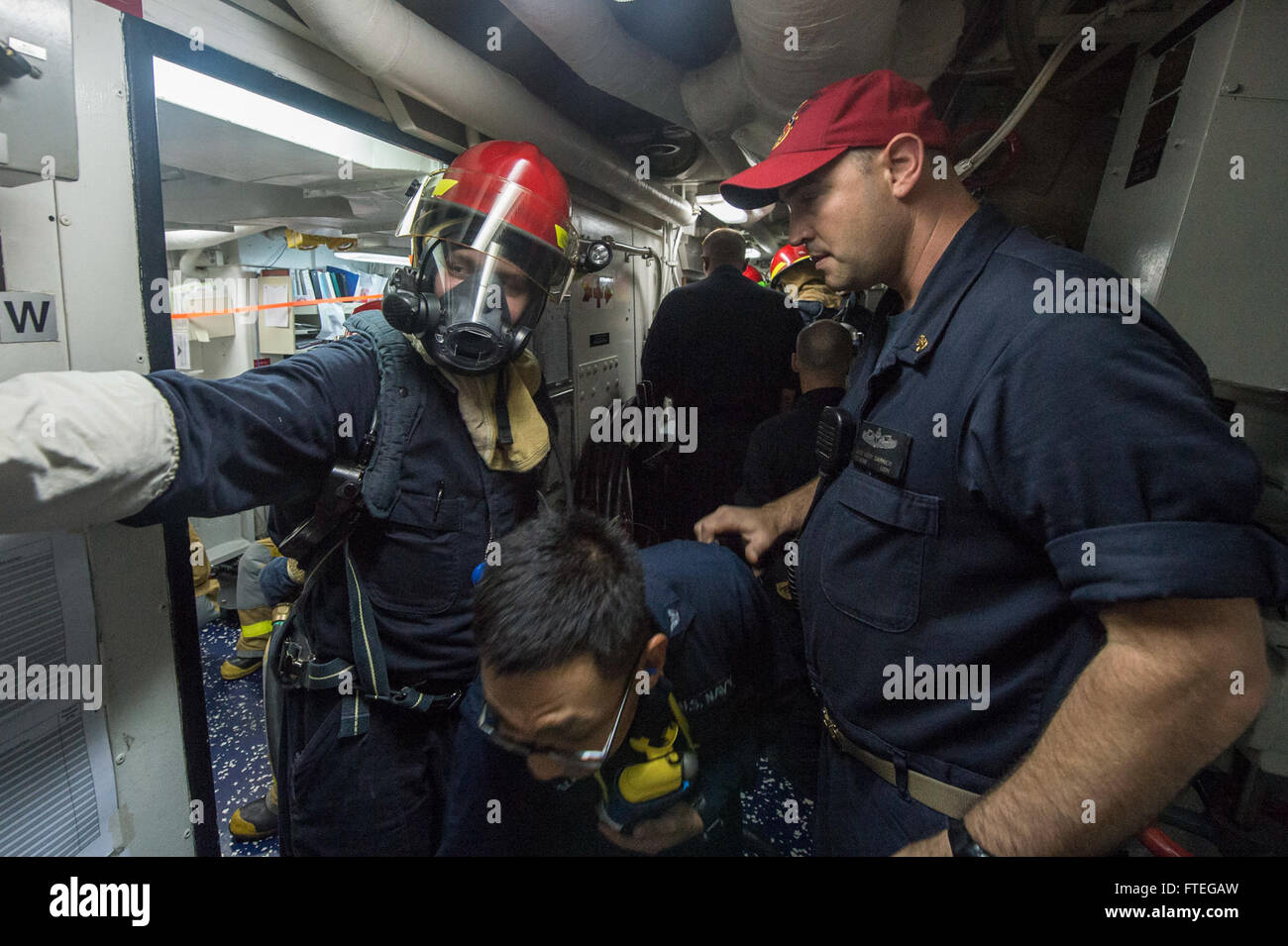 This image shows Damage Controlman 2nd Class Jeremy Key directing ...