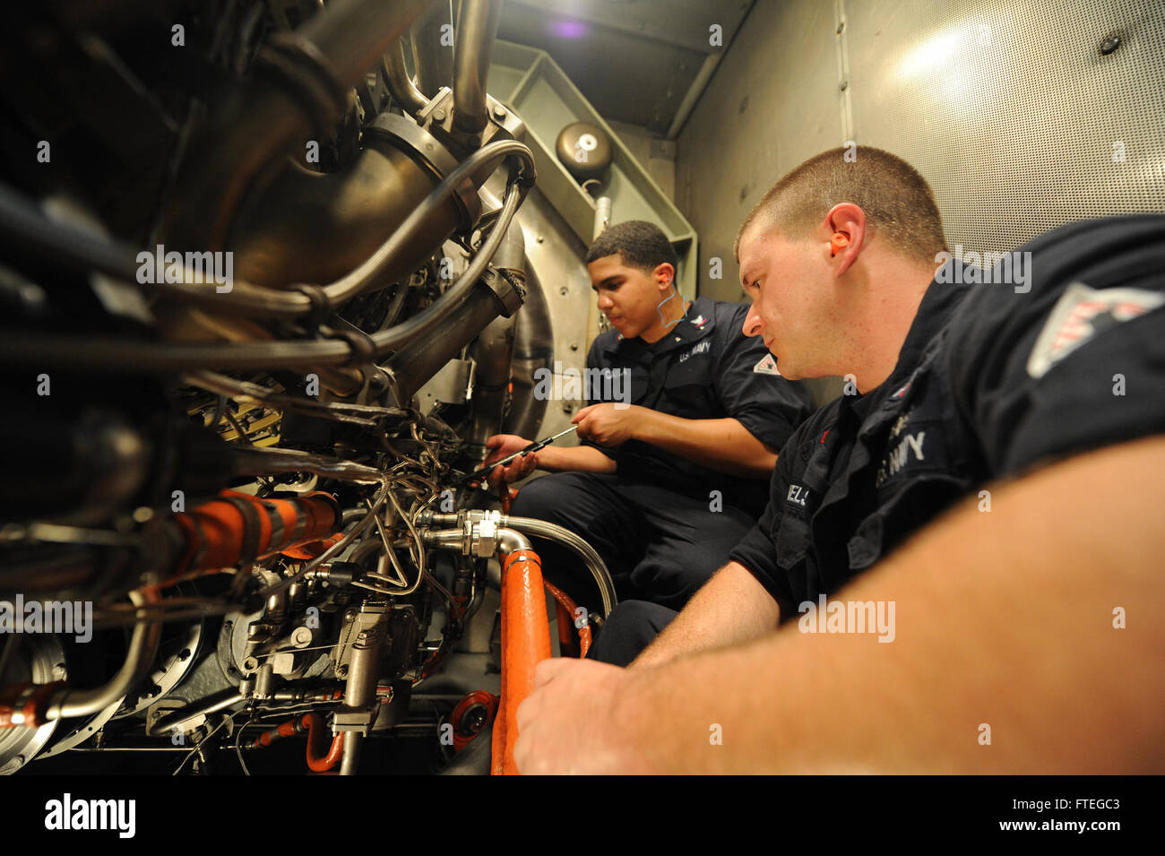 The image captures two Gas Turbine System Technicians aboard the USS ...