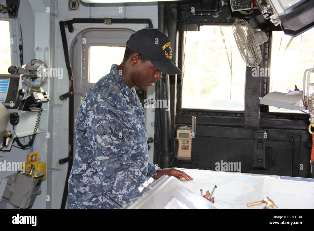 Quartermaster 2nd Class Christopher Kemp prepares a navigation chart ...