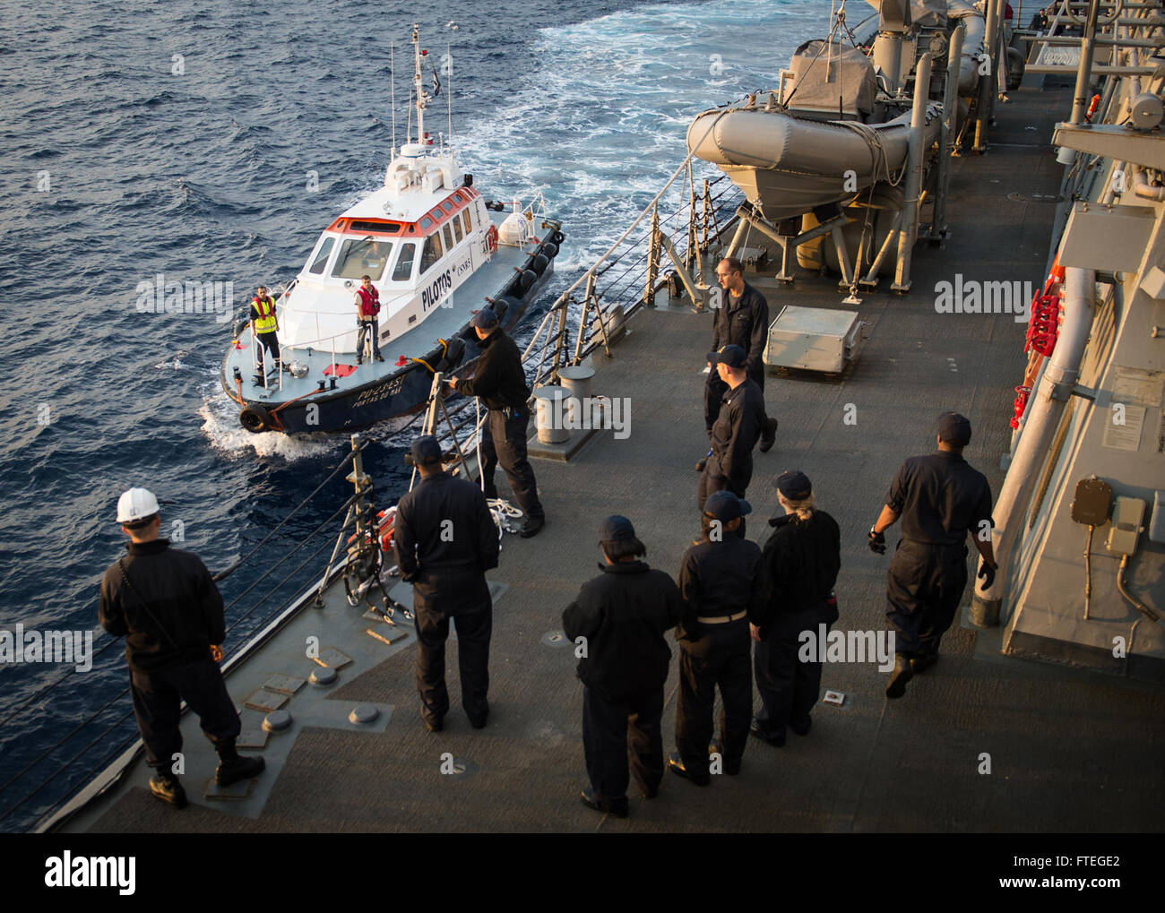 Sailors aboard the USS Mitscher (DDG 57) stand by for the arrival of a ...